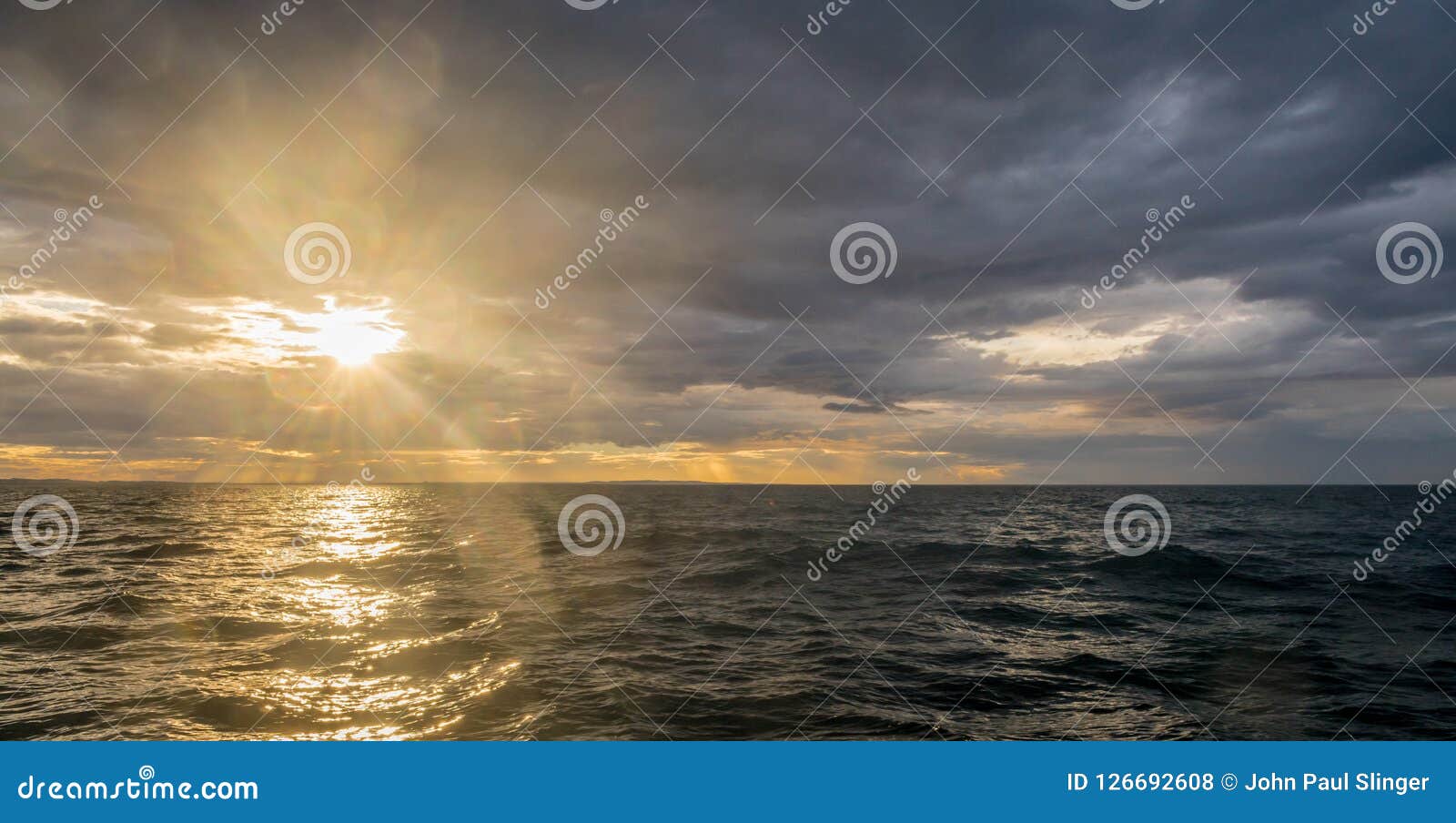 Storm Clouds with the Sun Setting and Sun Rays Over the Ocean. Stock ...