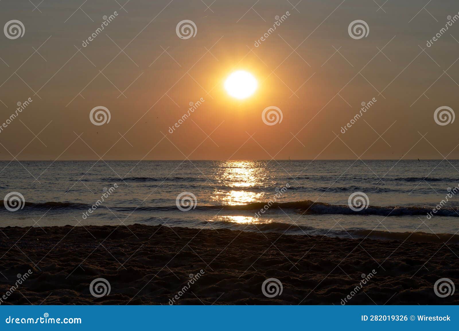The Sun Setting Over the Ocean from a Beach Side Setting Stock Photo ...
