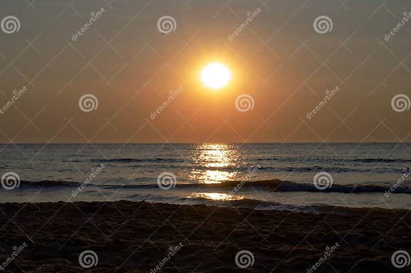 The Sun Setting Over the Ocean from a Beach Side Setting Stock Photo ...