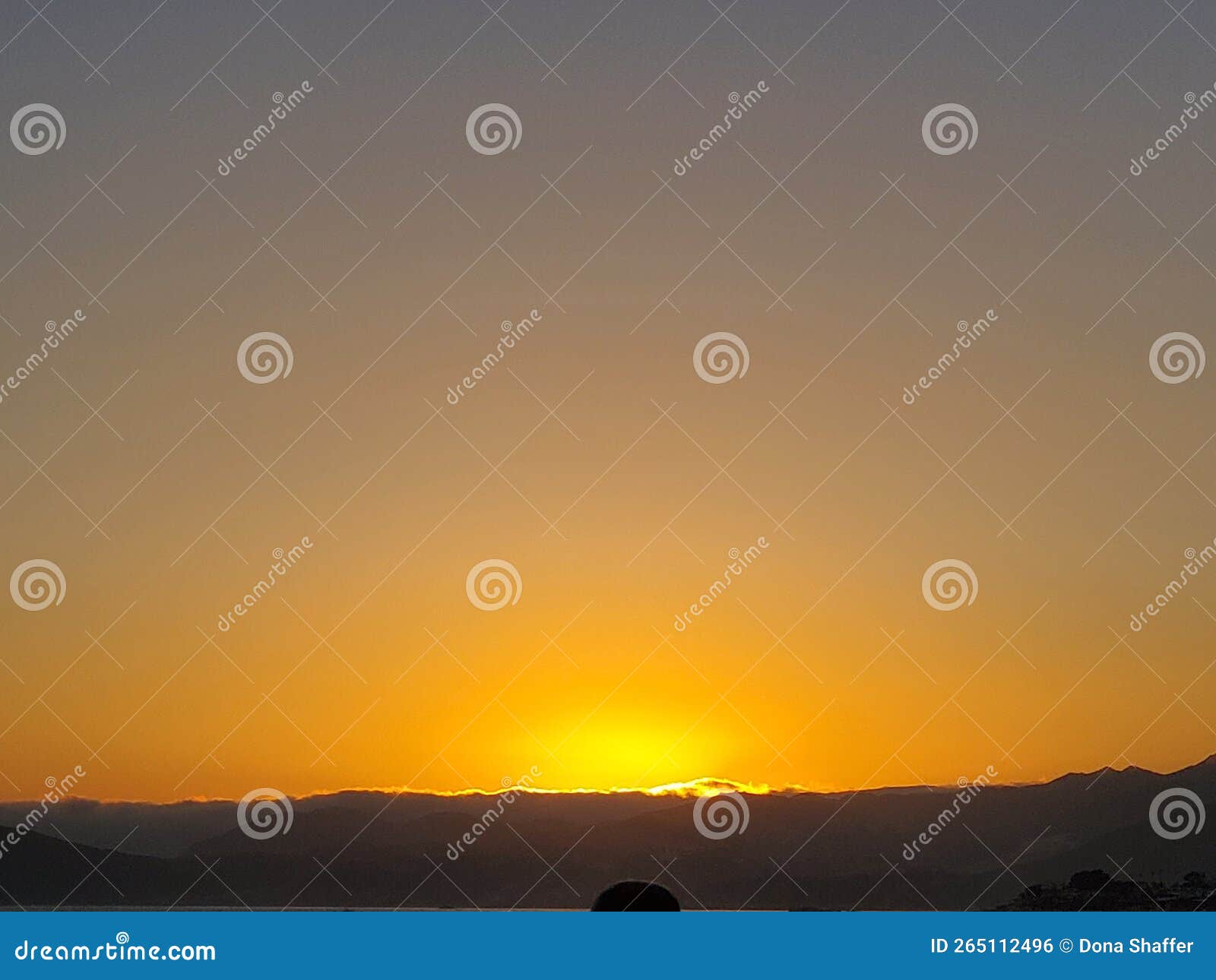 Sun Setting Over the Ocean and Distant Mountains Stock Photo - Image of ...