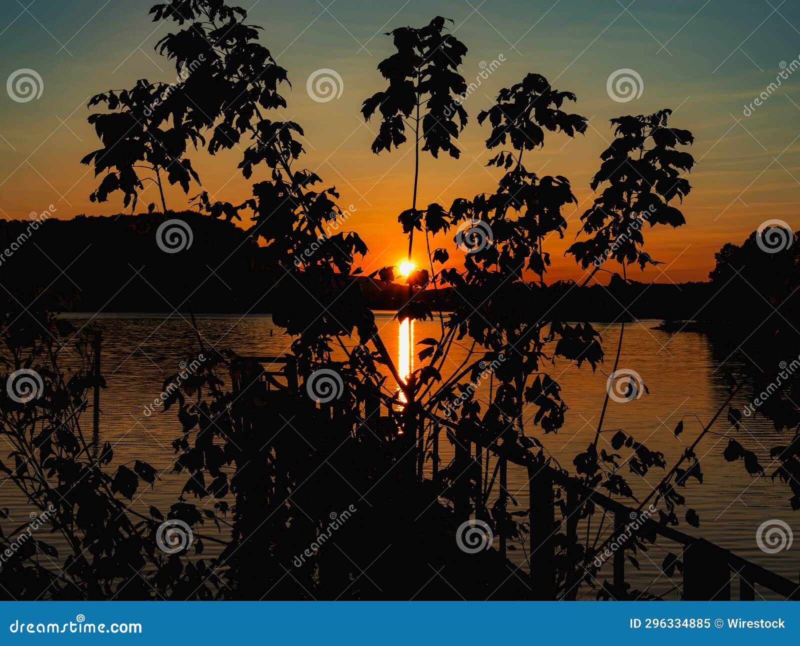 The Sun Setting Over the Water at Sunset on a Dock Stock Image - Image ...