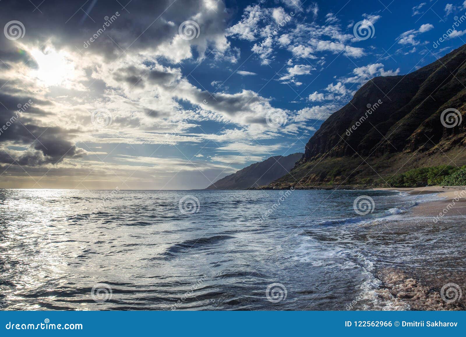 Sun Shining through the Clouds at Sandy Beach with Waves Stock Photo ...