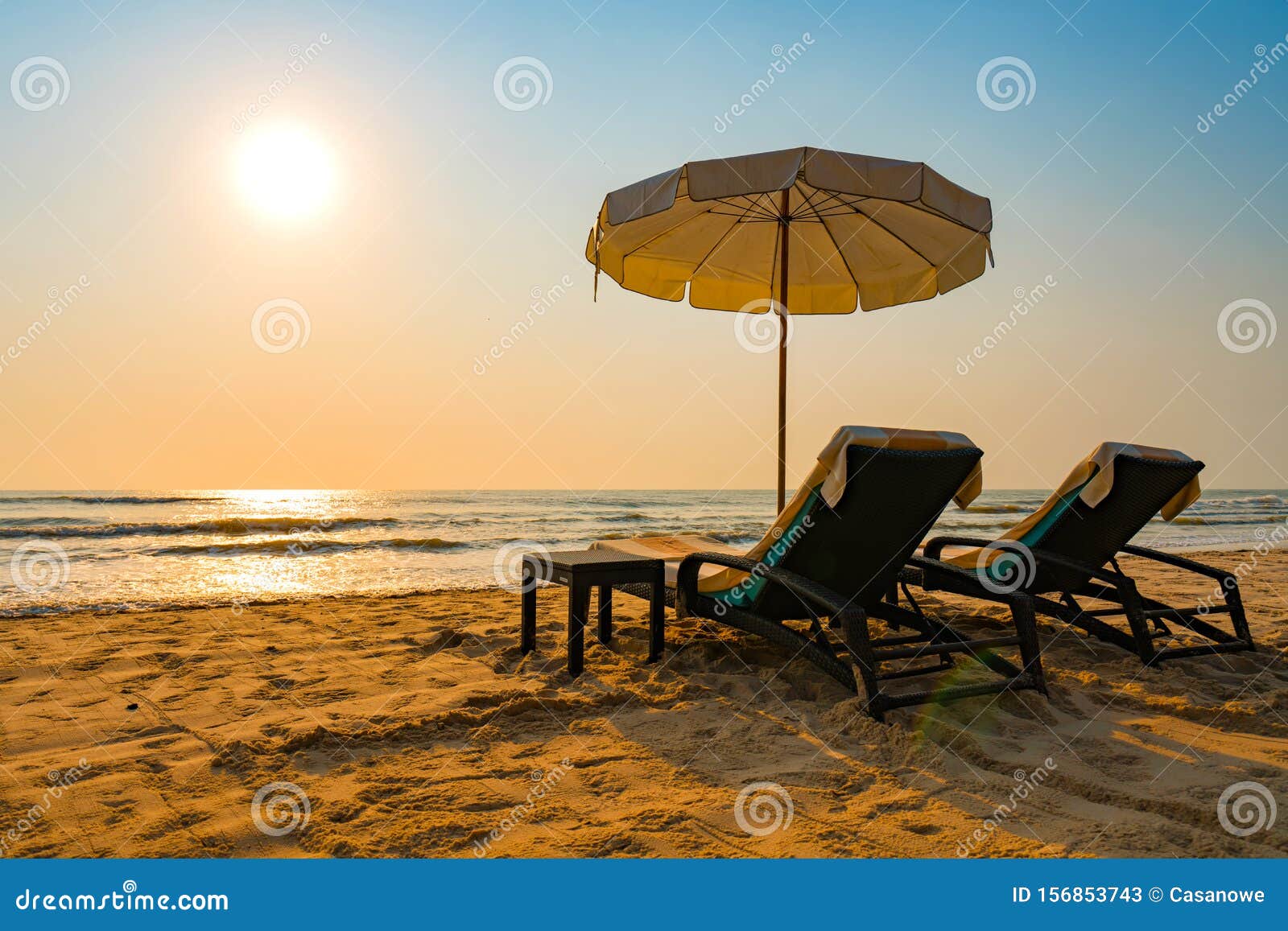 Sun Umbrellas And Chairs On Tropical Beach With Sunset Stock Image