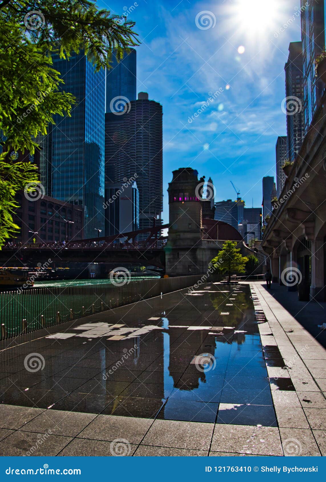 Sunbeams Extend Over Splash Pad With Reflections Of Cityscape On ...