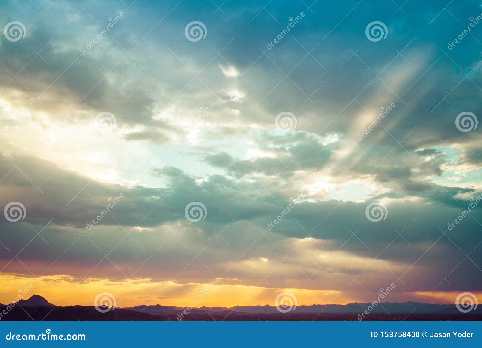 Sunbeams Radiating Out Under Colorful Clouds Stock Photo - Image of ...