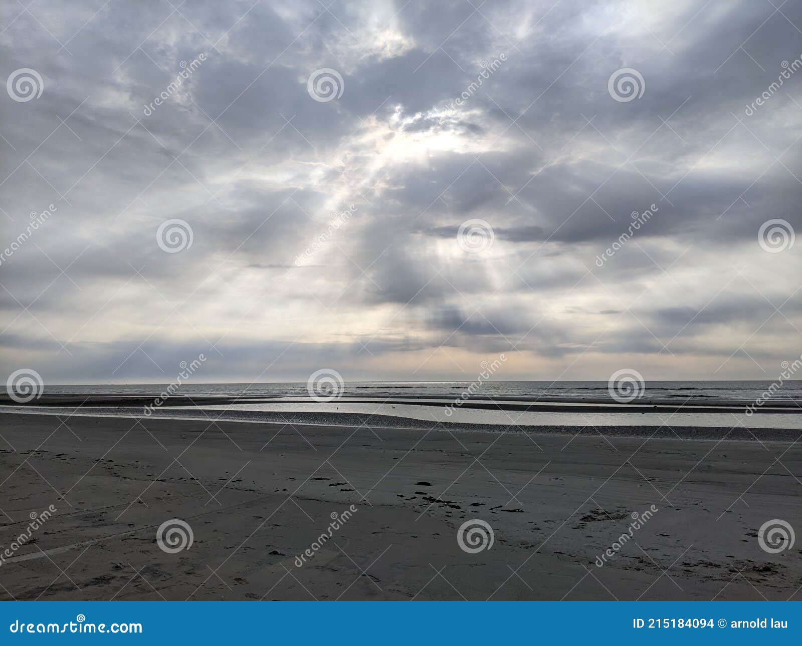 Sunlight Coming through Clouds Over Beach and Ocean Stock Photo - Image ...
