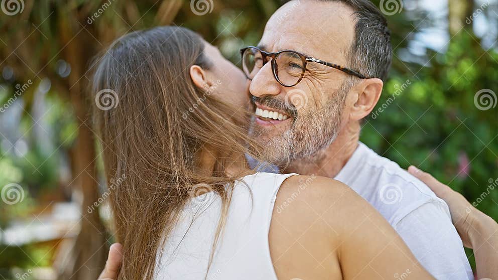 In The Sunny Park A Confident Father Shares A Joyful Smiling Hug With