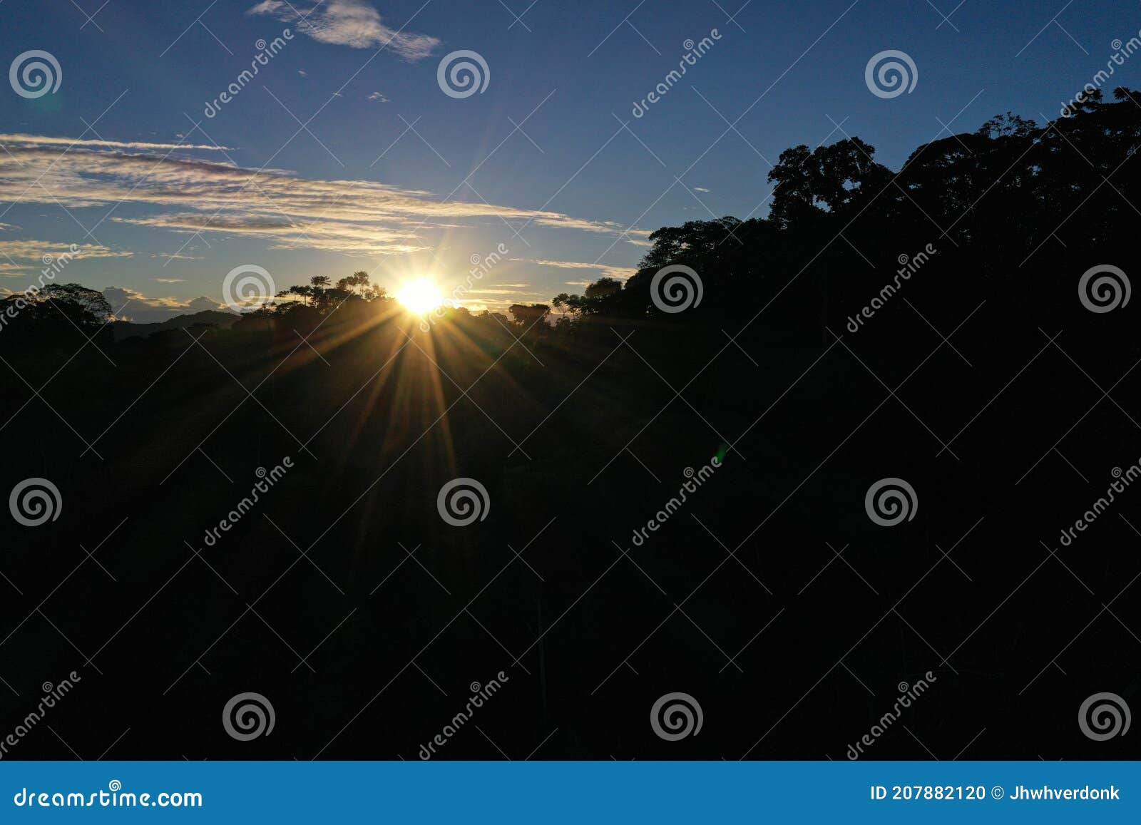 Sunset Above a Tropical Rainforest with Sunbeams Over the Canopy Stock ...