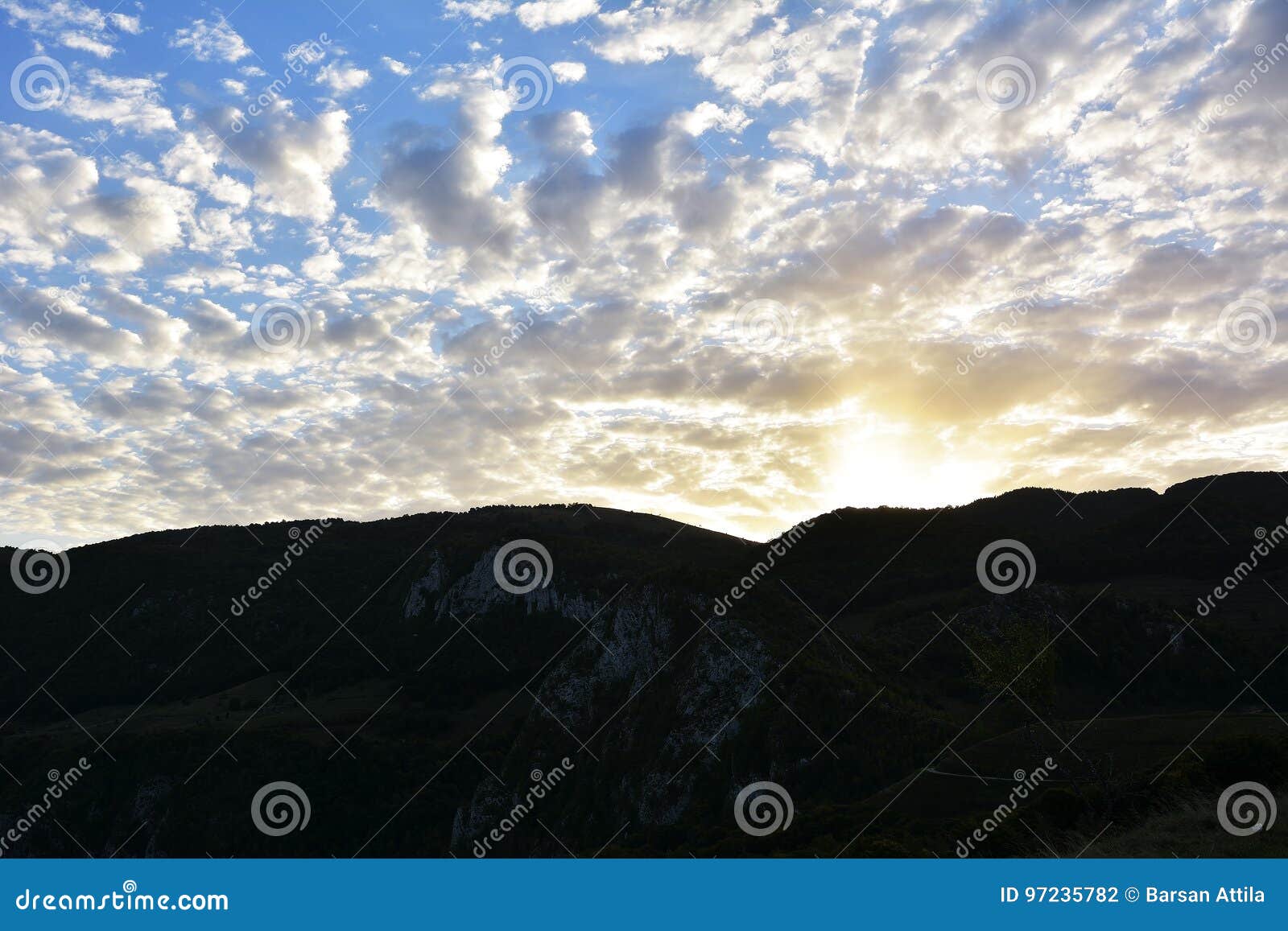 The Sunset Behind Mountain with Beautiful Sunbeam through the Cloud ...