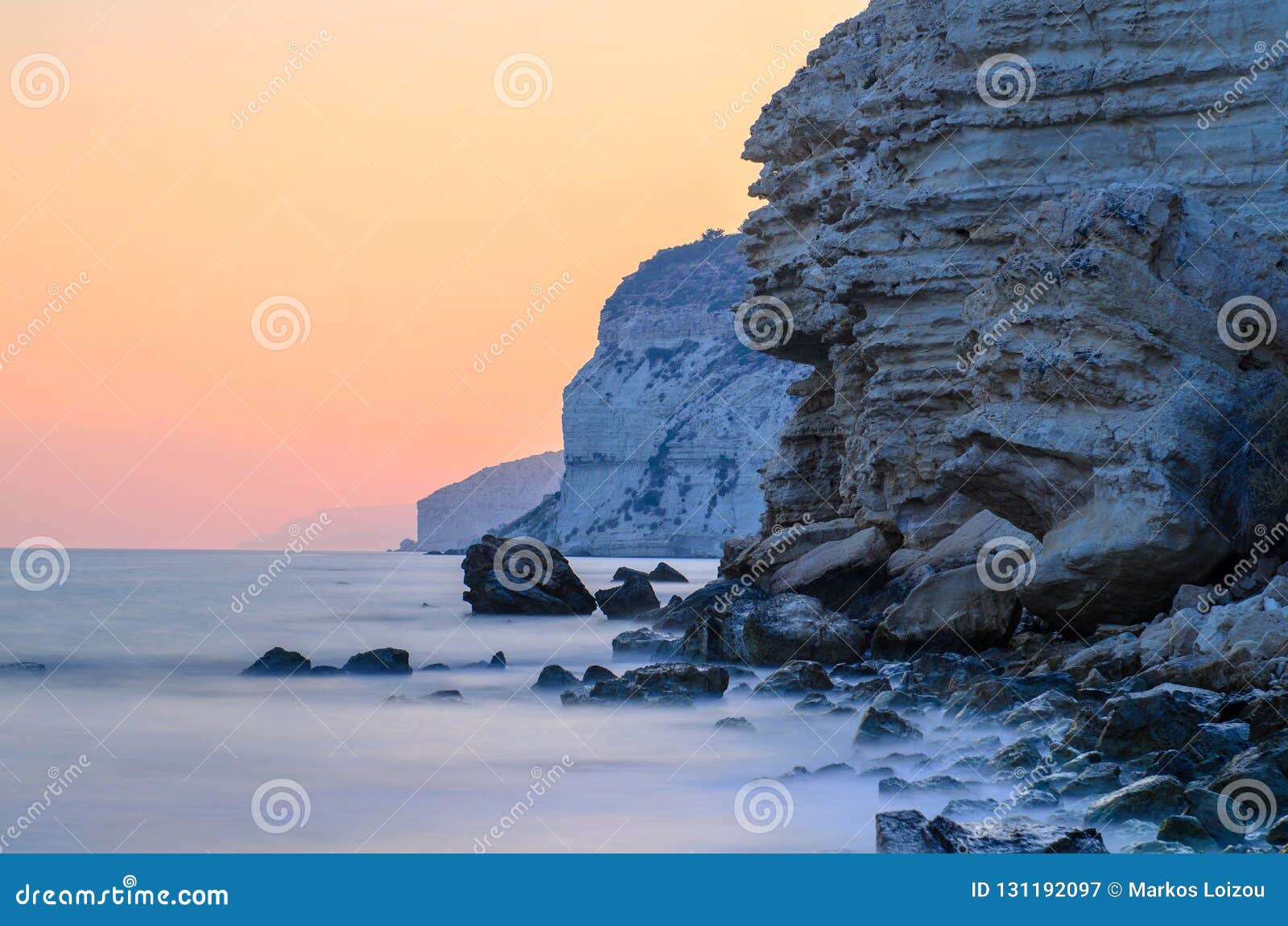Sunset behind rock cliffs stock image. Image of ocean - 131192097