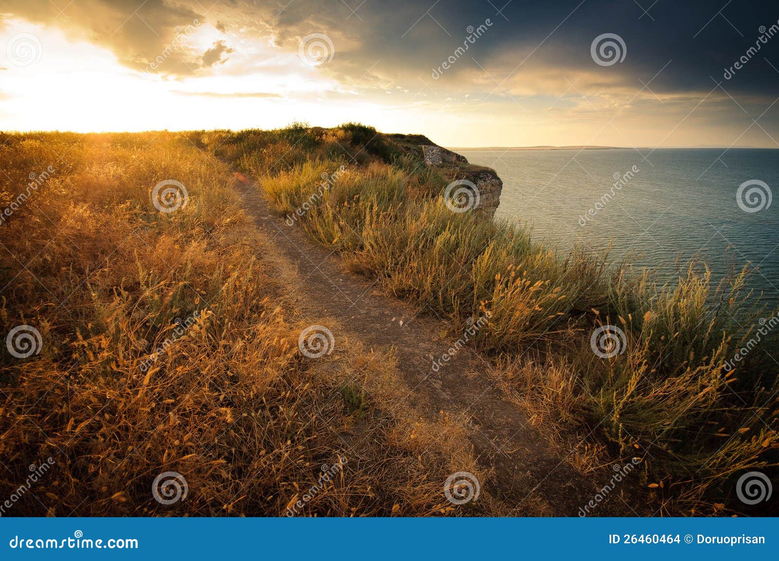 Sunset on the Cliff Near a Lake Stock Photo - Image of yellow, sunset ...