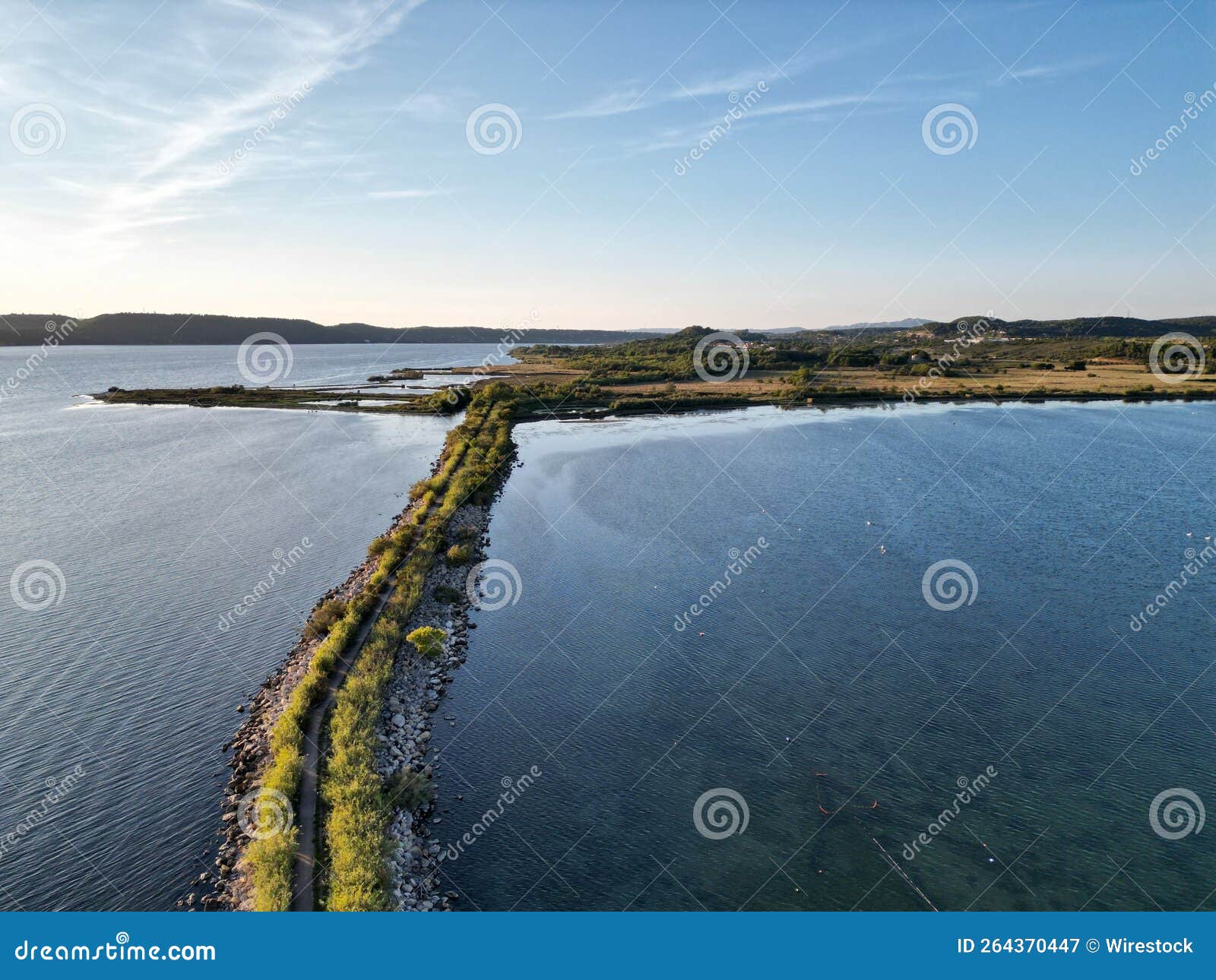 Sunset Drone View of a Jetty Walkway in a Blue Lagoon with Mountains in ...