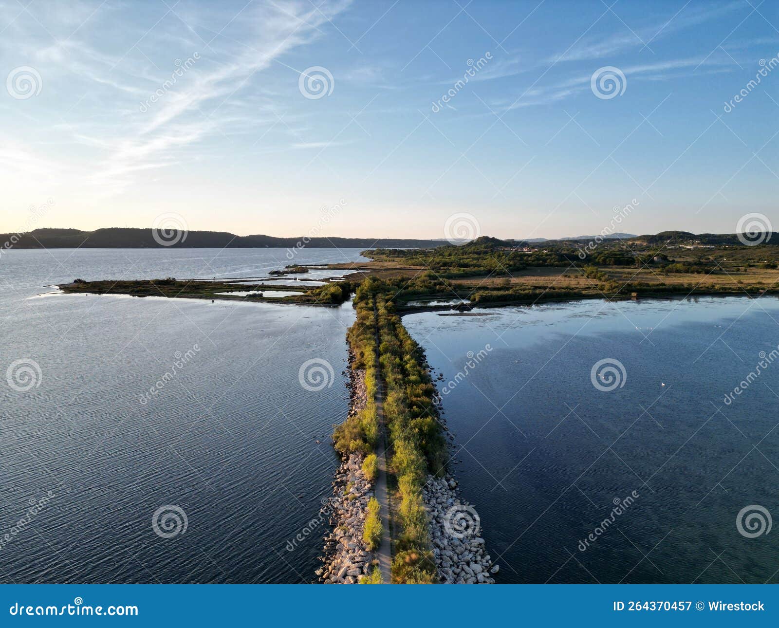 Sunset Drone View of a Jetty Walkway in a Blue Lagoon with Mountains in ...