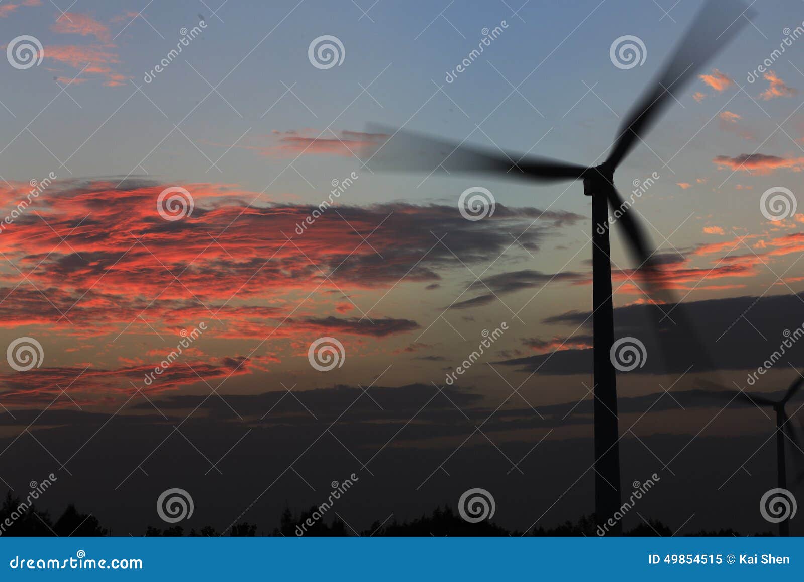 In the Sunset Glow in the Background of a Wind Turbine in the Power ...