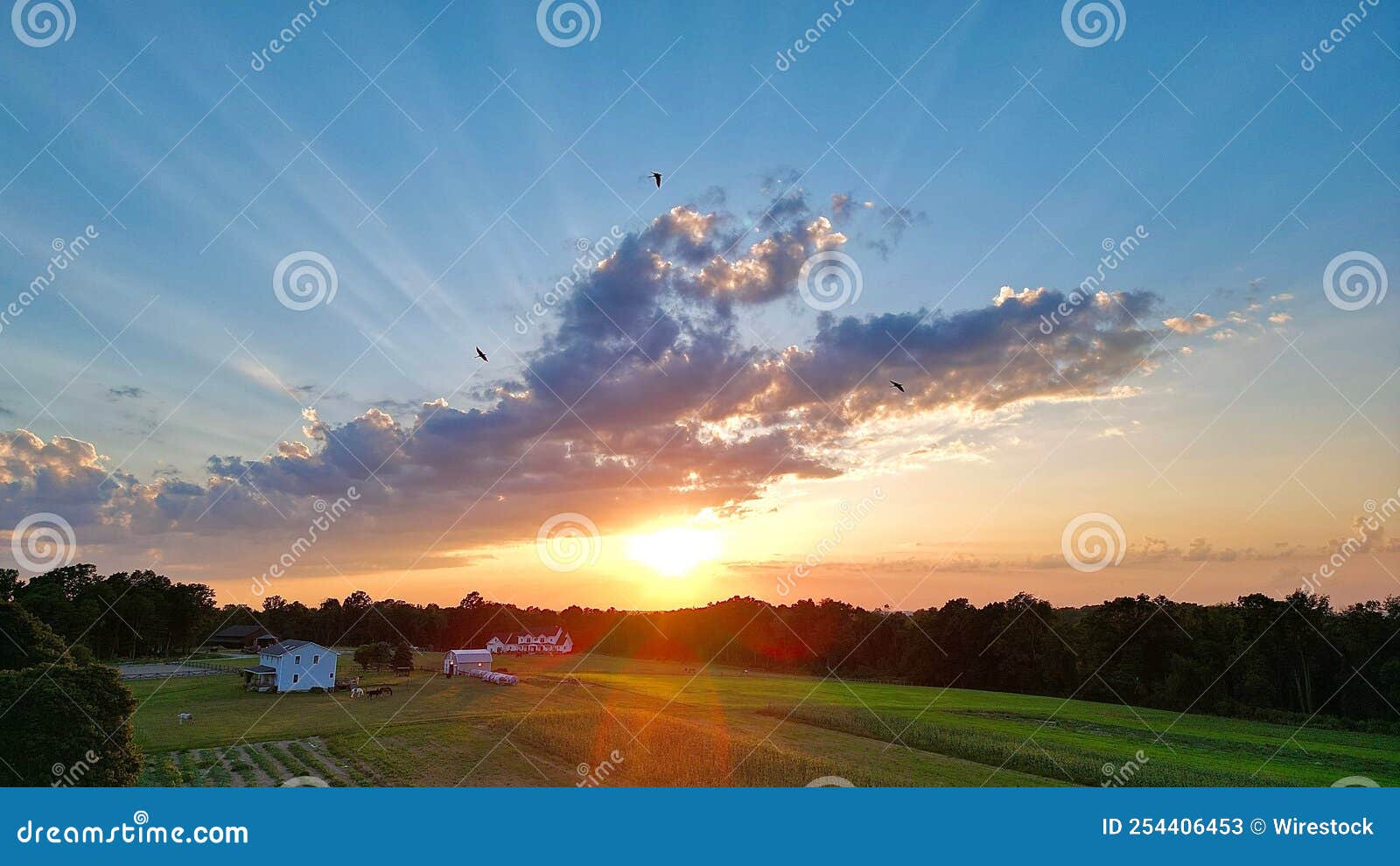 Sunset with Light Rays through the Clouds Over a Field in West ...