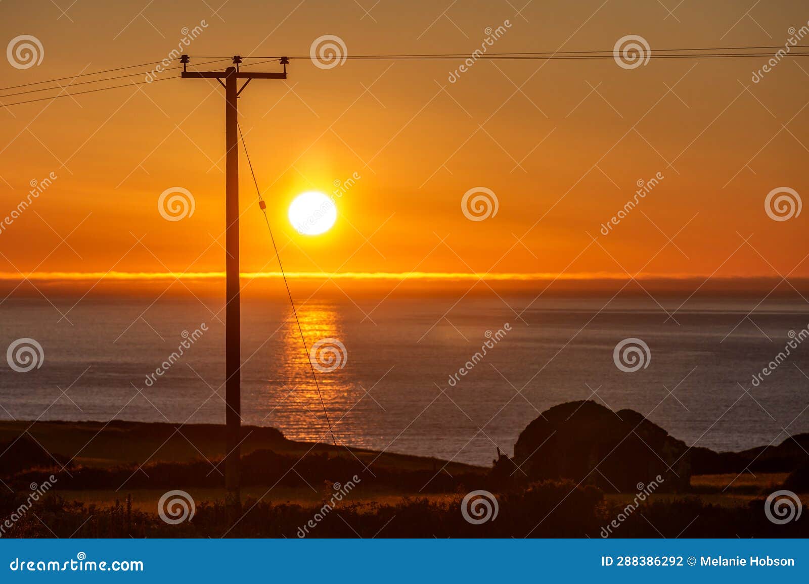 Sunset Over the Ocean with a Silhouetted Telegraph Pole in the ...