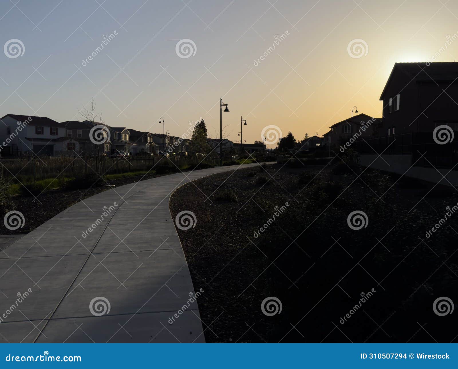 Sunset Over a Pathway Flanked by Houses Stock Photo - Image of horizon ...