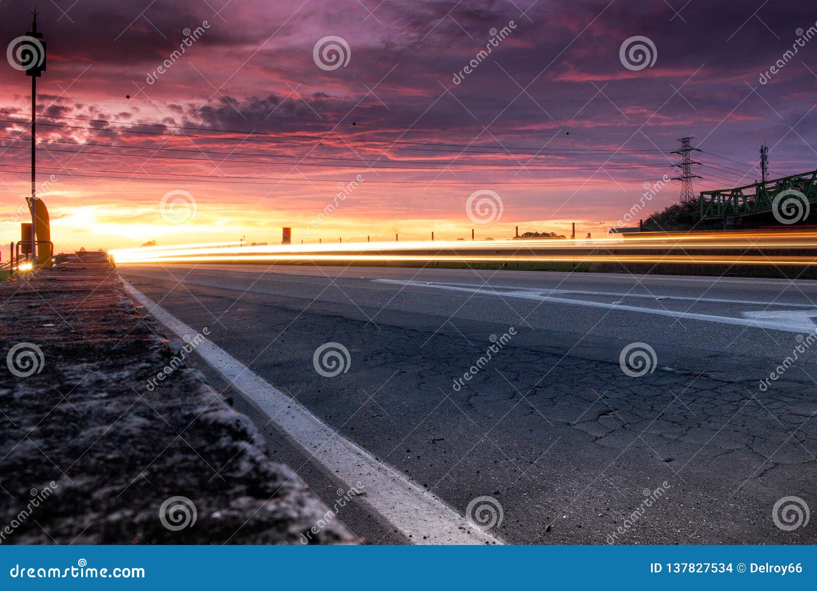 Sunset over road stock photo. Image of dawn, pylon, sundown - 137827534