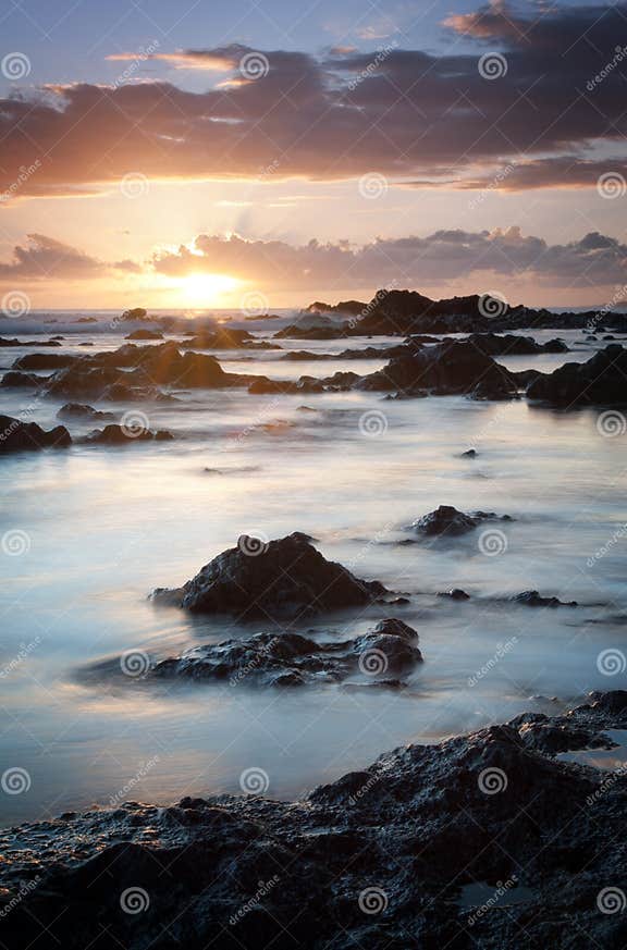 Sunset over rocky coast stock image. Image of boulder - 19921657