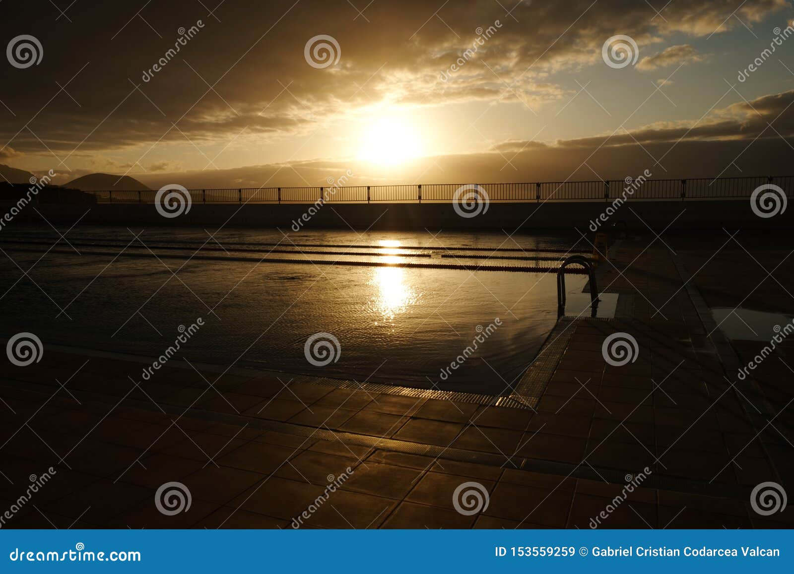 Sunset over swimming pool stock image. Image of destination - 153559259