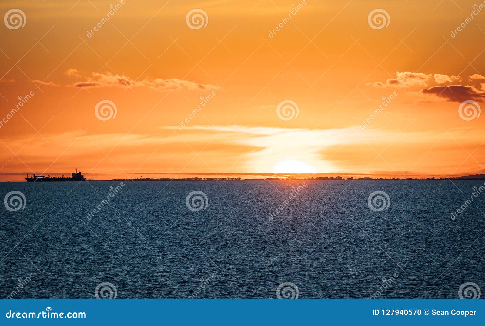 Sunset Over Water with Cargo Ship and Clouds Stock Photo - Image of ...