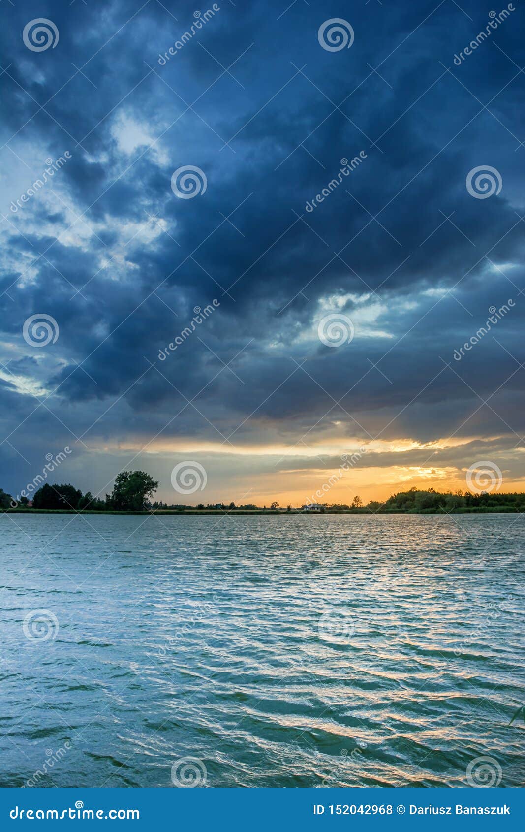 Sunset Over the Water and Dark Clouds in the Sky Stock Photo - Image of ...