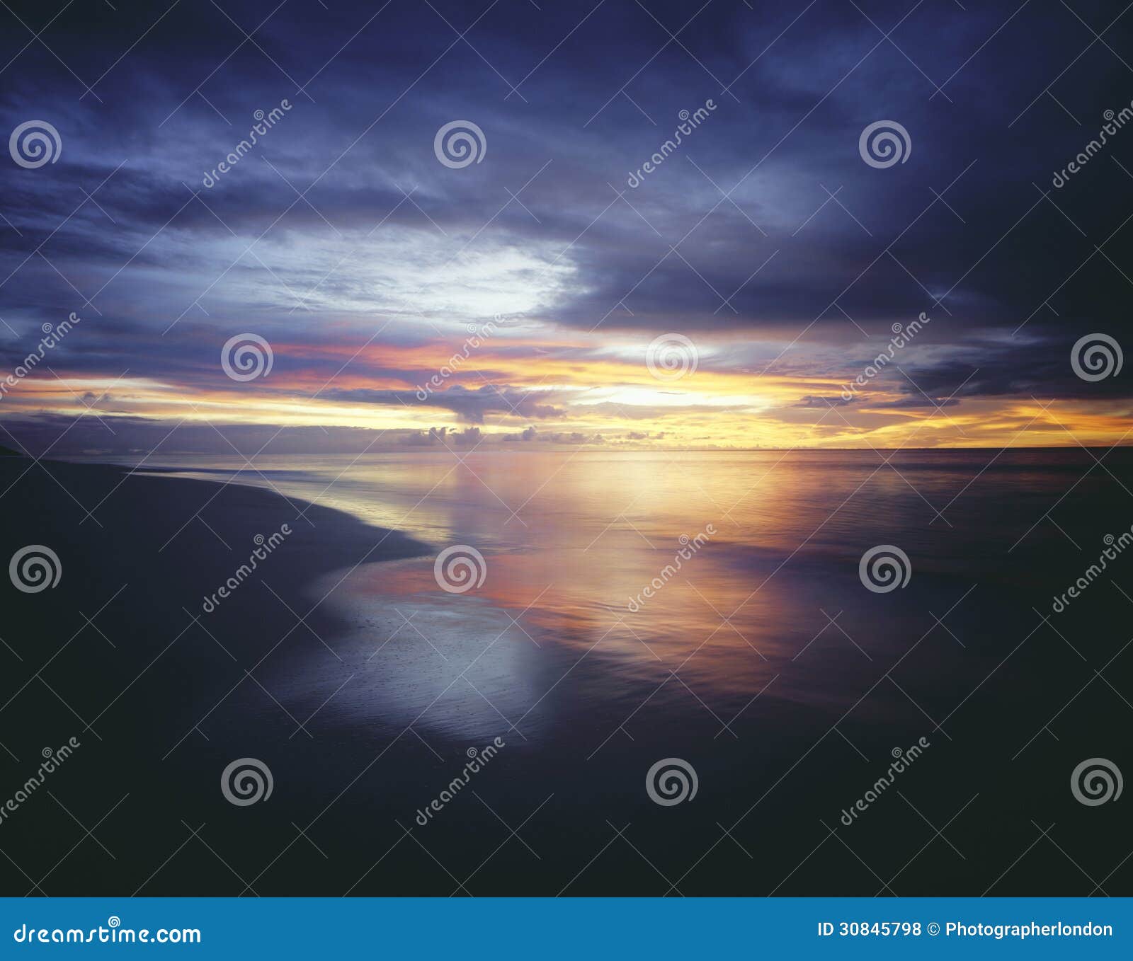 Sunset and Overcast Sky Over Beach Stock Photo - Image of scenic ...