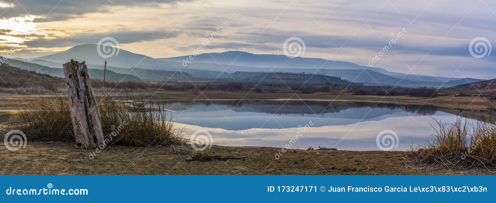 Sunset Panorama Over a Small Lake with Sun and Cloud Reflection on the ...