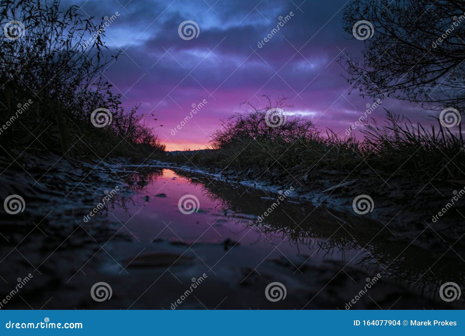 The Sunset is Reflected in a Puddle of a Road Stock Photo - Image of ...