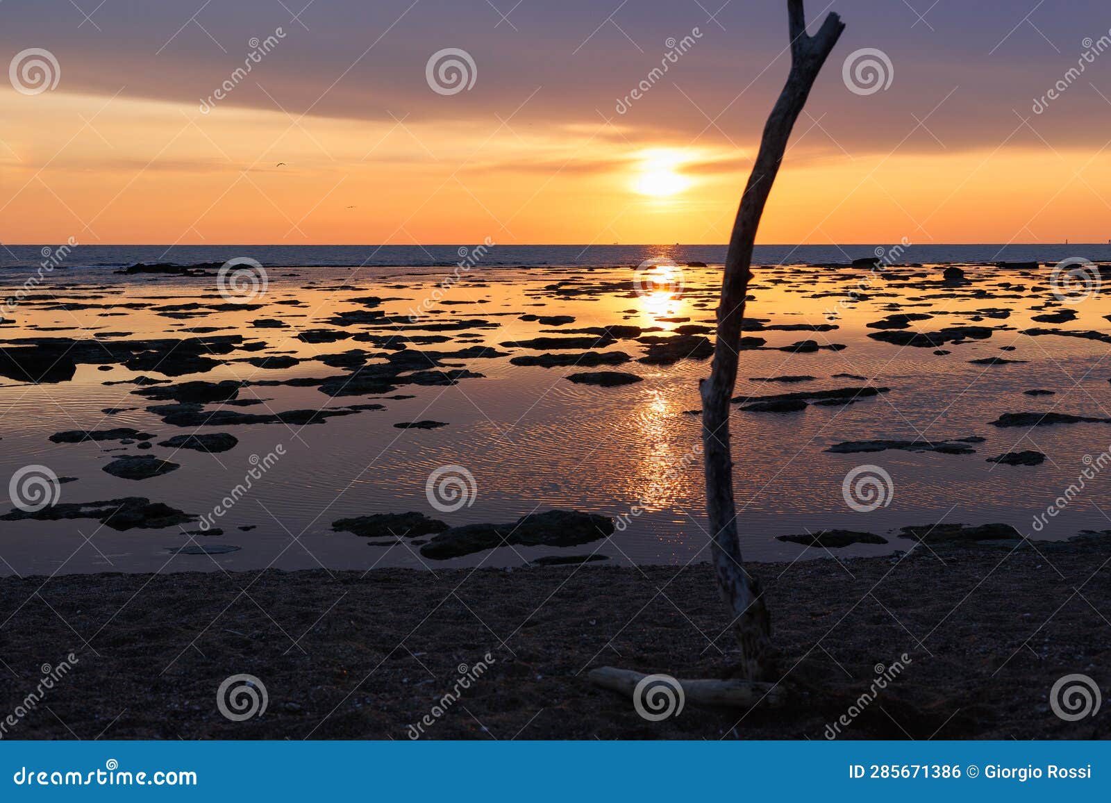 Sunset Reflected on the Sea As in a Mirror with Rocks Emerging on the ...