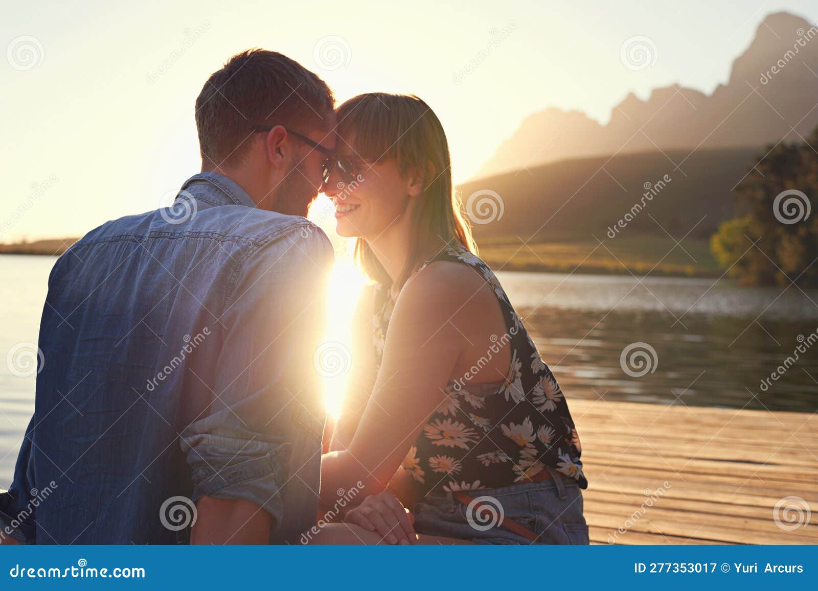 Sunset Romance. an Affectionate Young Couple Sitting on a Dock at ...