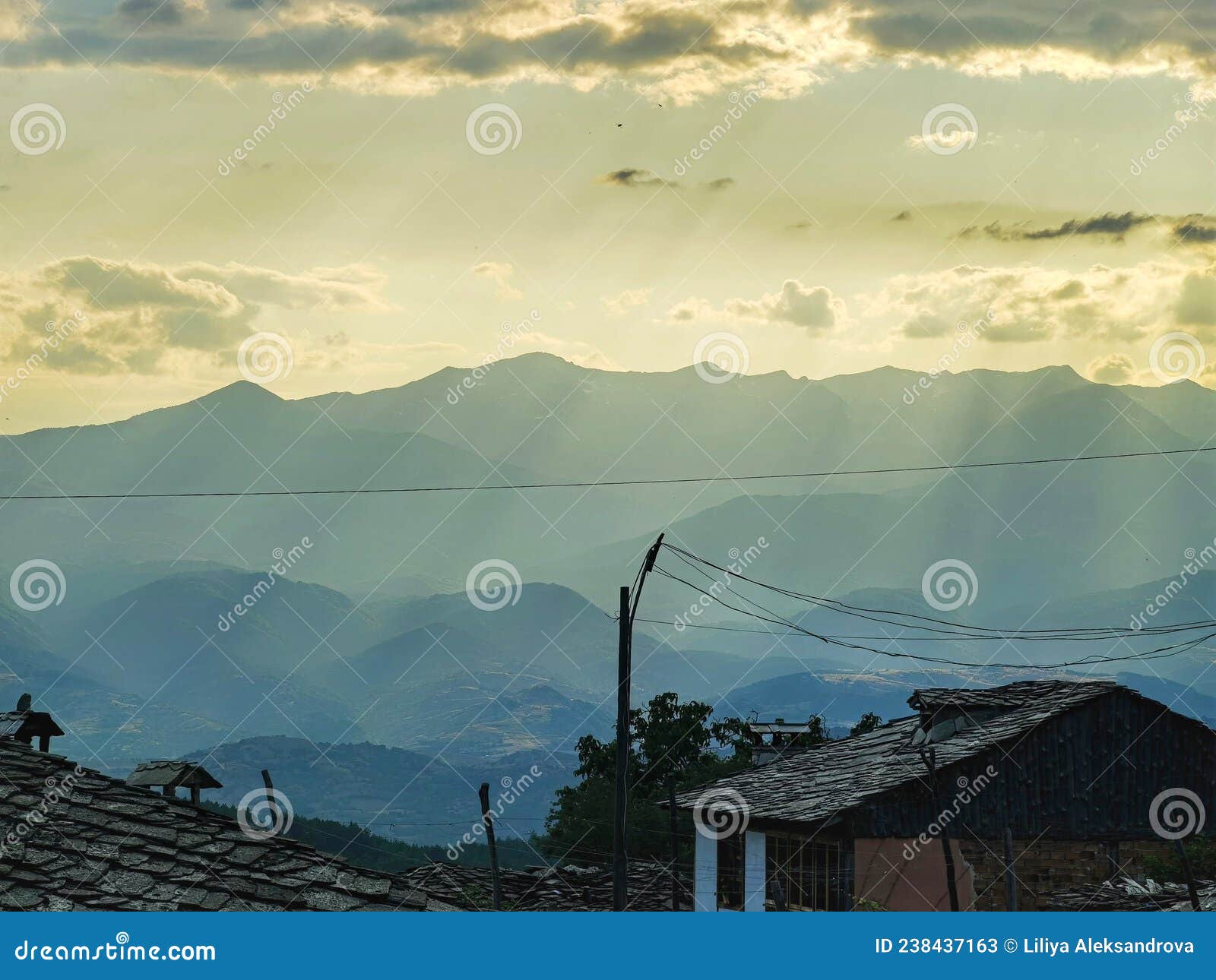 Sunset View Above House Roofs with Light Rays from the Clouds Stock ...