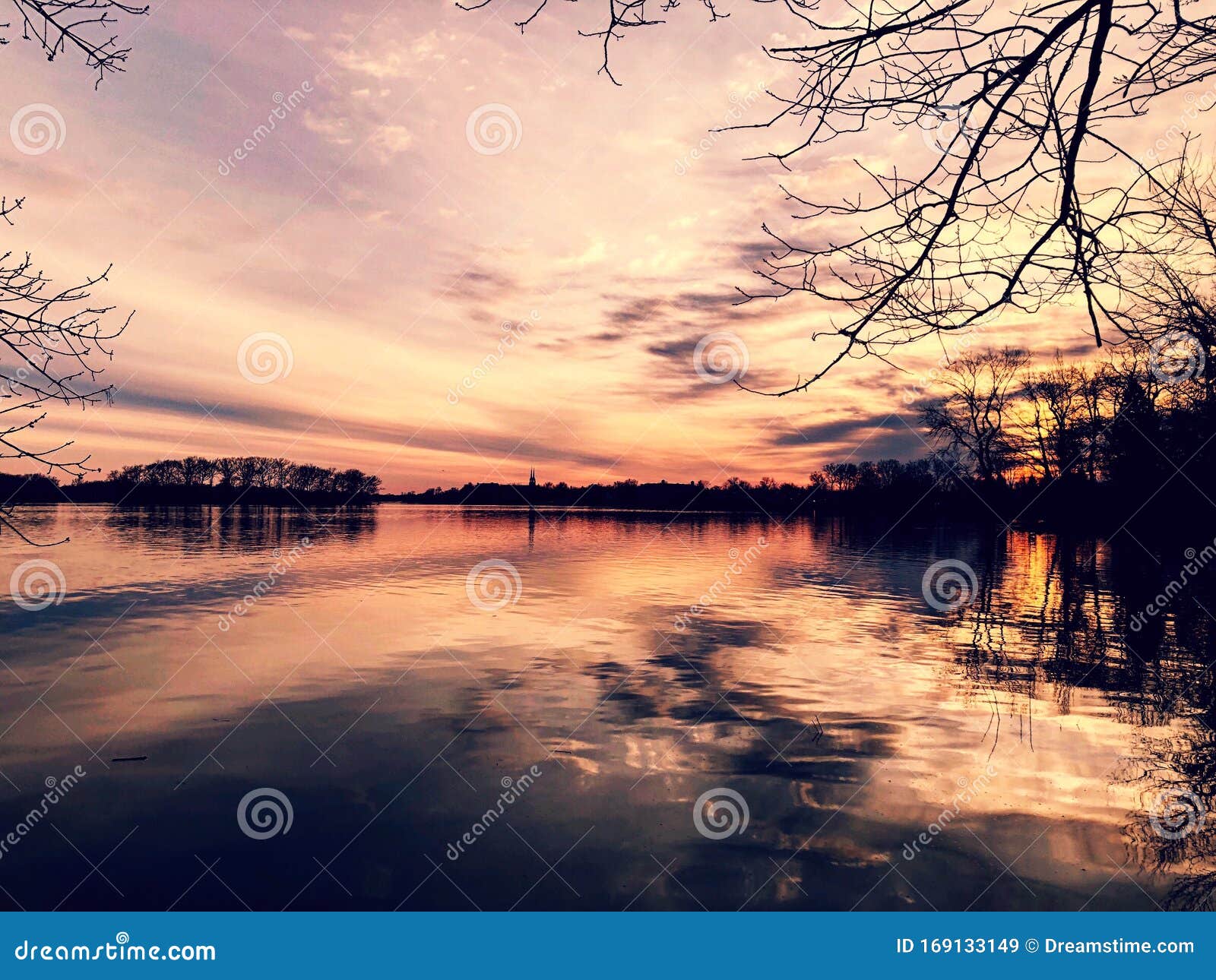 Sunset by the water stock image. Image of reflection - 169133149