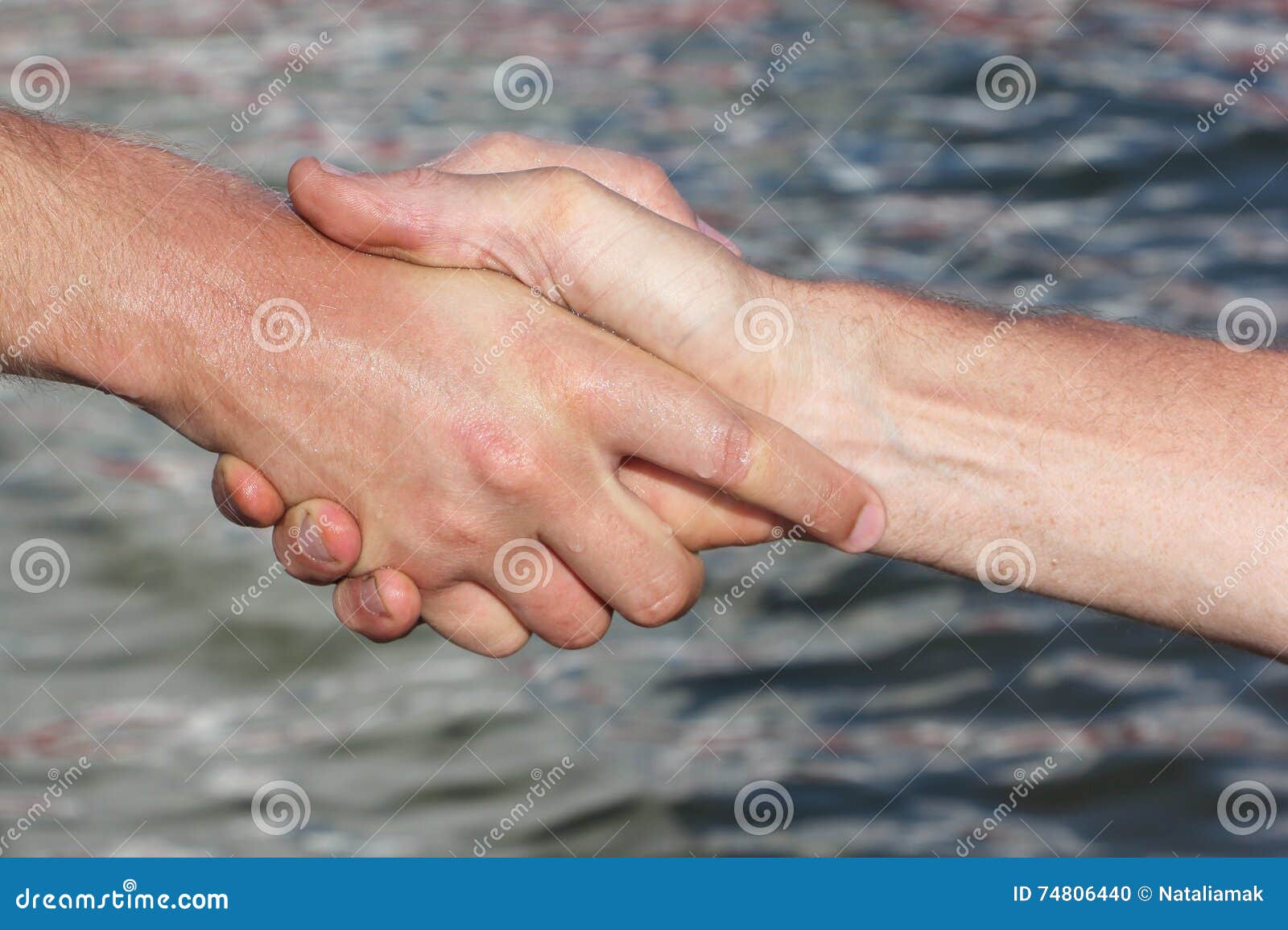 Suntanned Male Hands Make Handshake Against a Water Stock Photo - Image ...