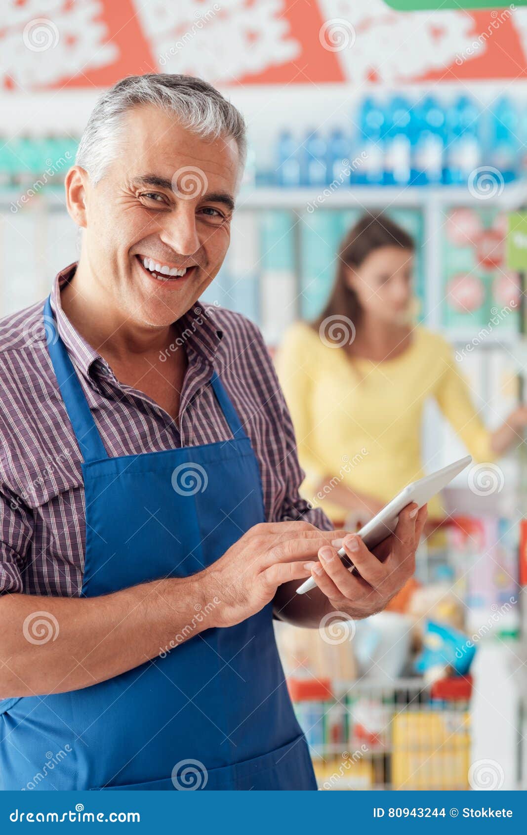 Supermarket Clerk Using a Tablet Stock Photo - Image of apron, device ...
