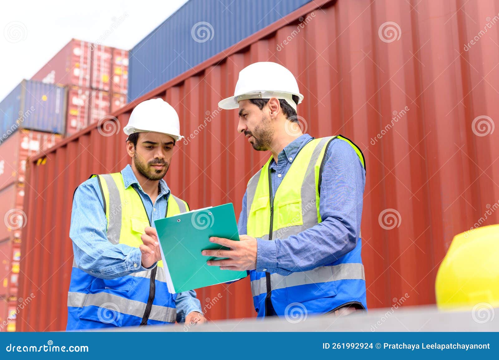 Supervisor and Colleagues in White Hard Hats and Safety Vests Stand in ...
