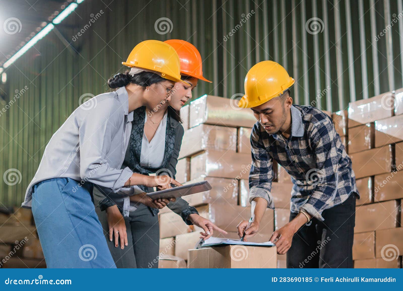 Supervisor Corrects the Work of Two Factory Employees during a Visit ...