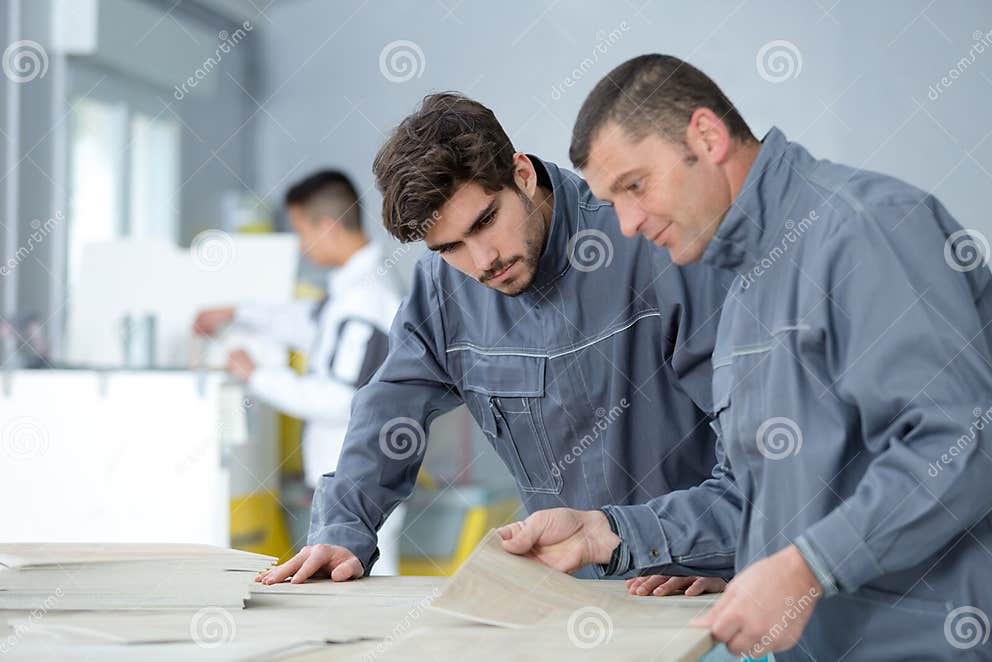 Supervisor Holding Paperwork with Workers in Factory Stock Photo ...