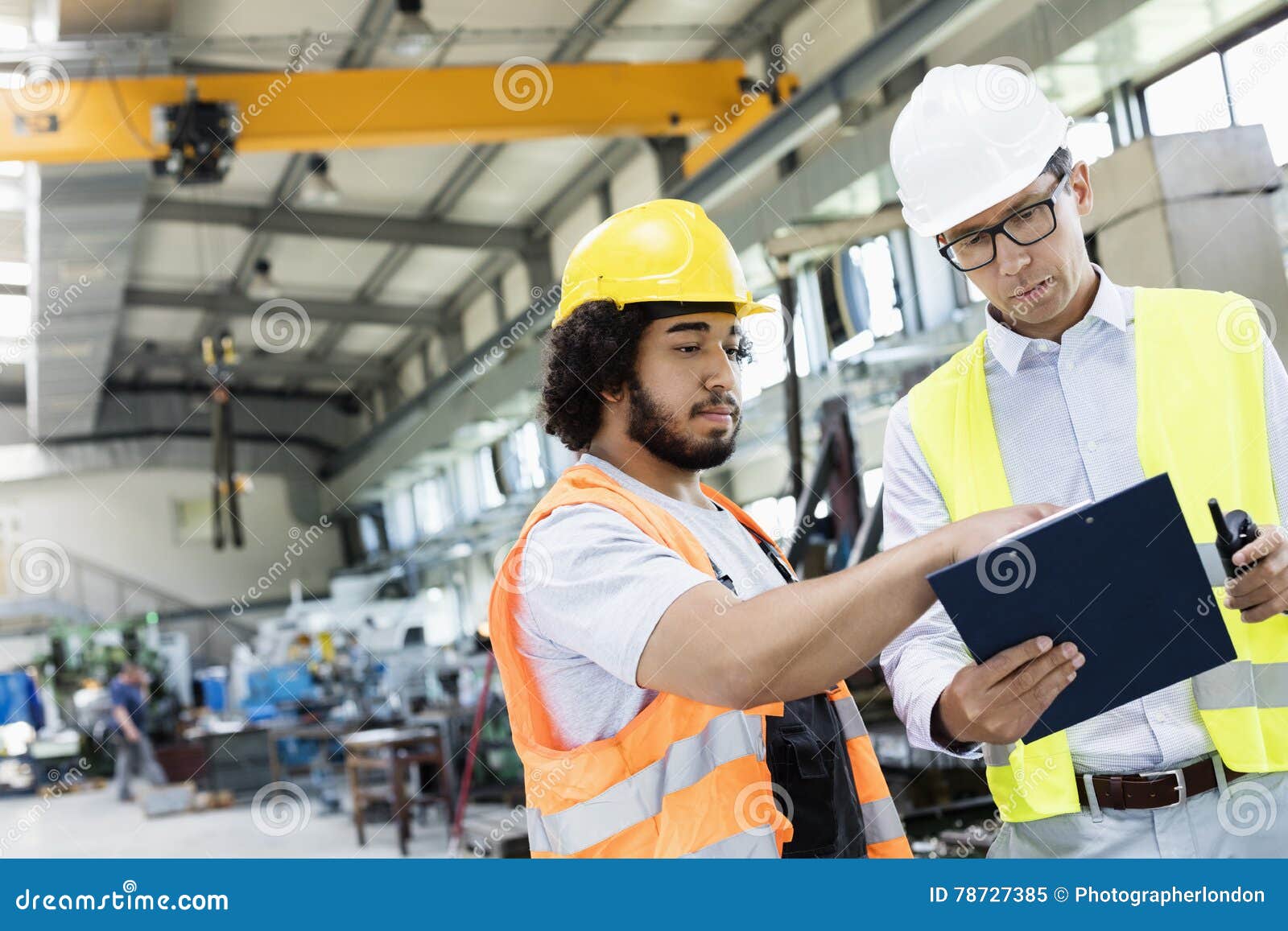 Supervisor with Manual Worker Discussing Over Clipboard in Metal ...