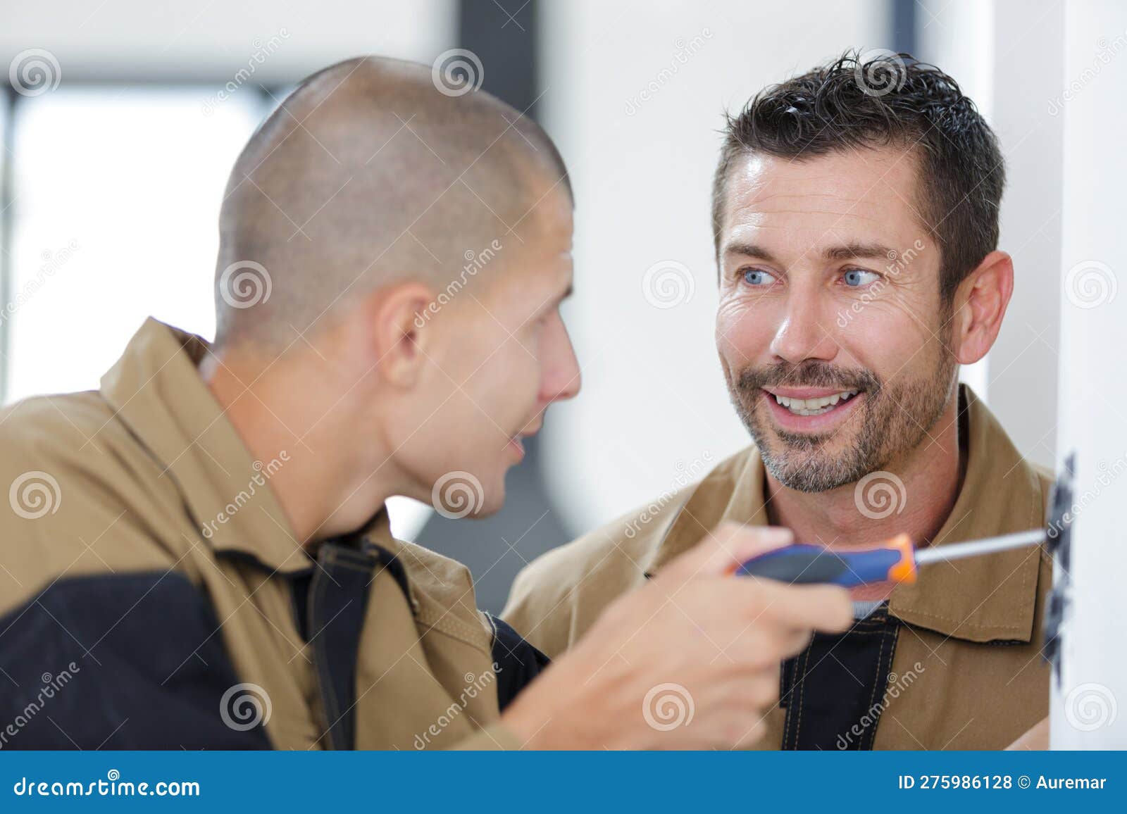 Supervisor Overseeing Apprentice Tradesman Using Screwdriver Stock ...