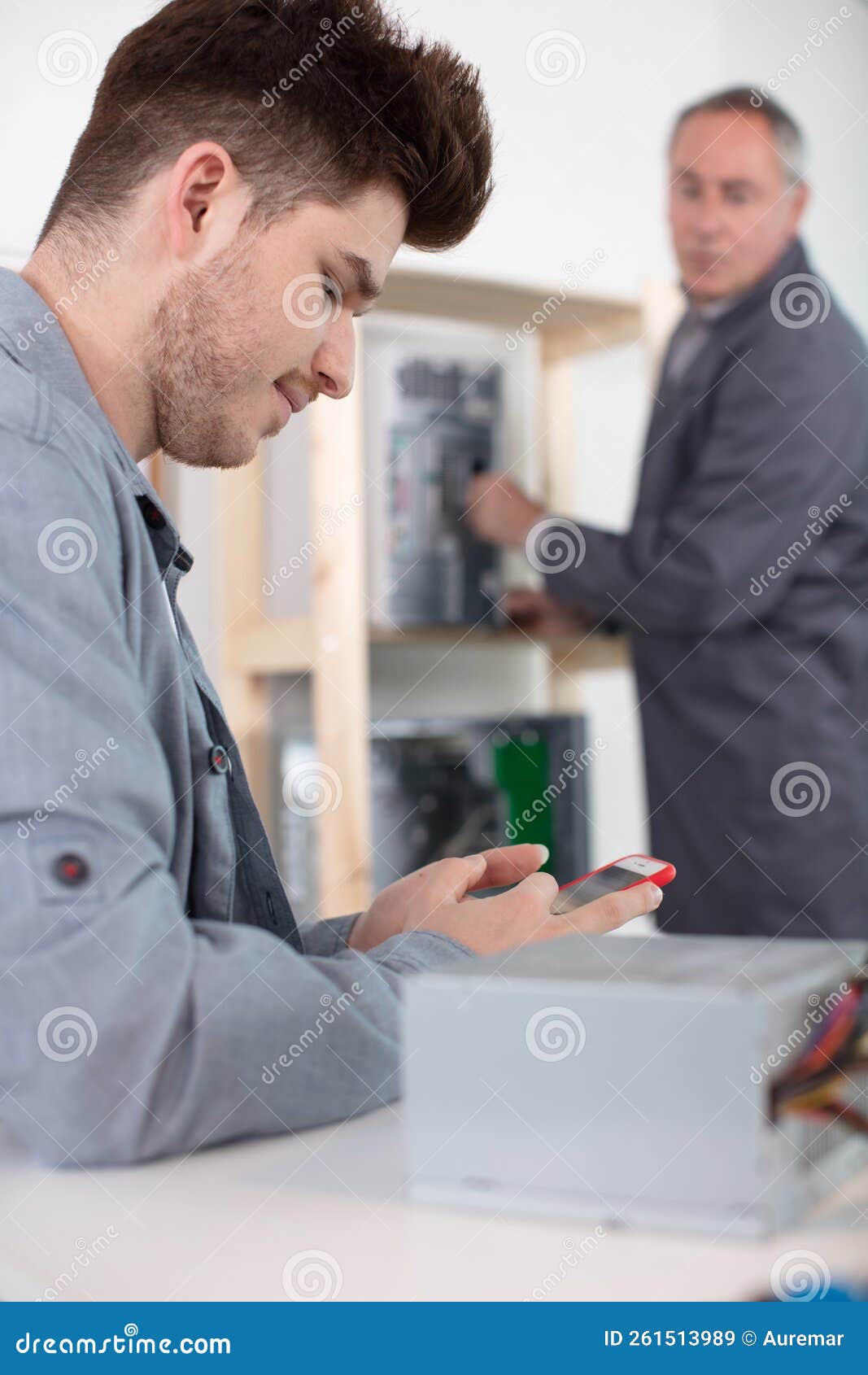 Supervisor Spots Apprentice Using Smartphone at Work Stock Image ...