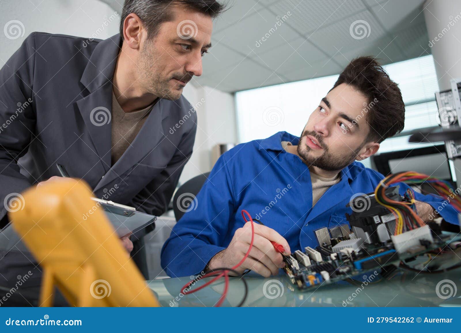 Supervisor Talking To Electronics Apprentice Using Multimeter Stock ...