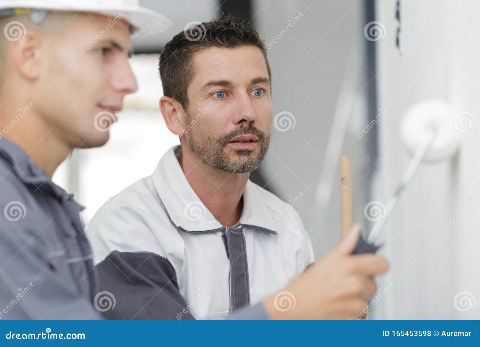Supervisor Watching Apprentice Painter Use Roller Stock Photo - Image ...