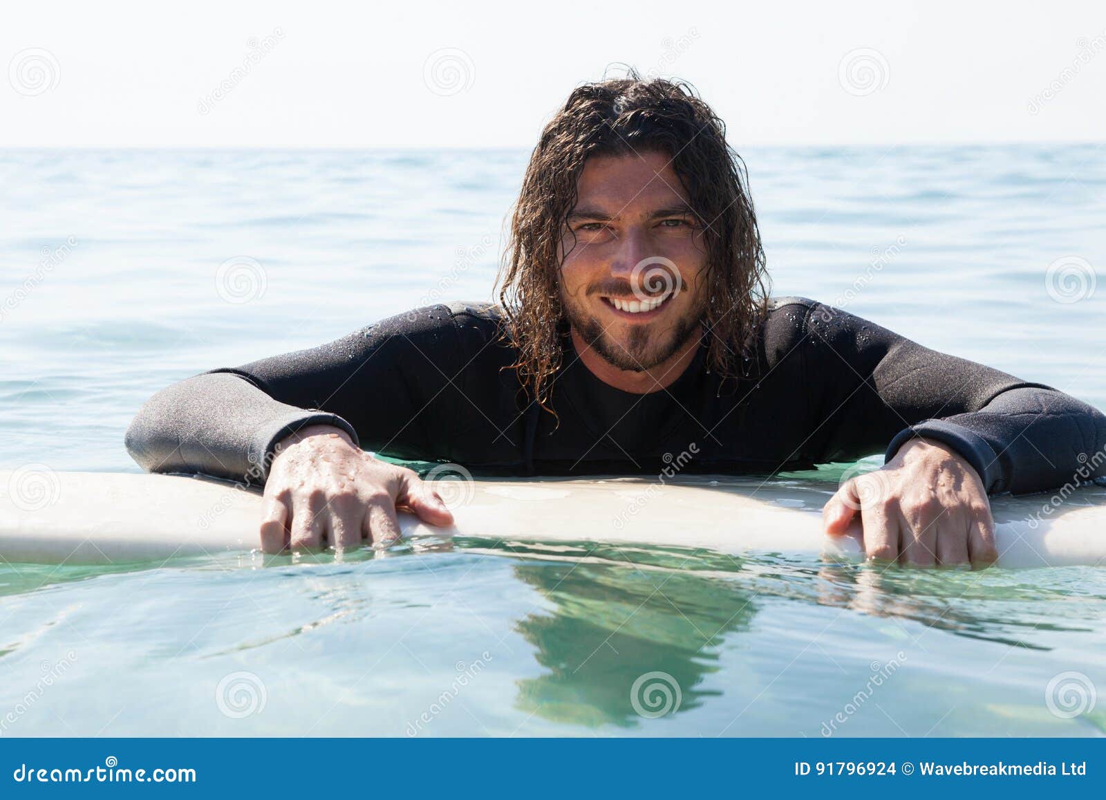 Surfer Leaning on Surfboard in Sea Stock Photo - Image of male, sunny ...