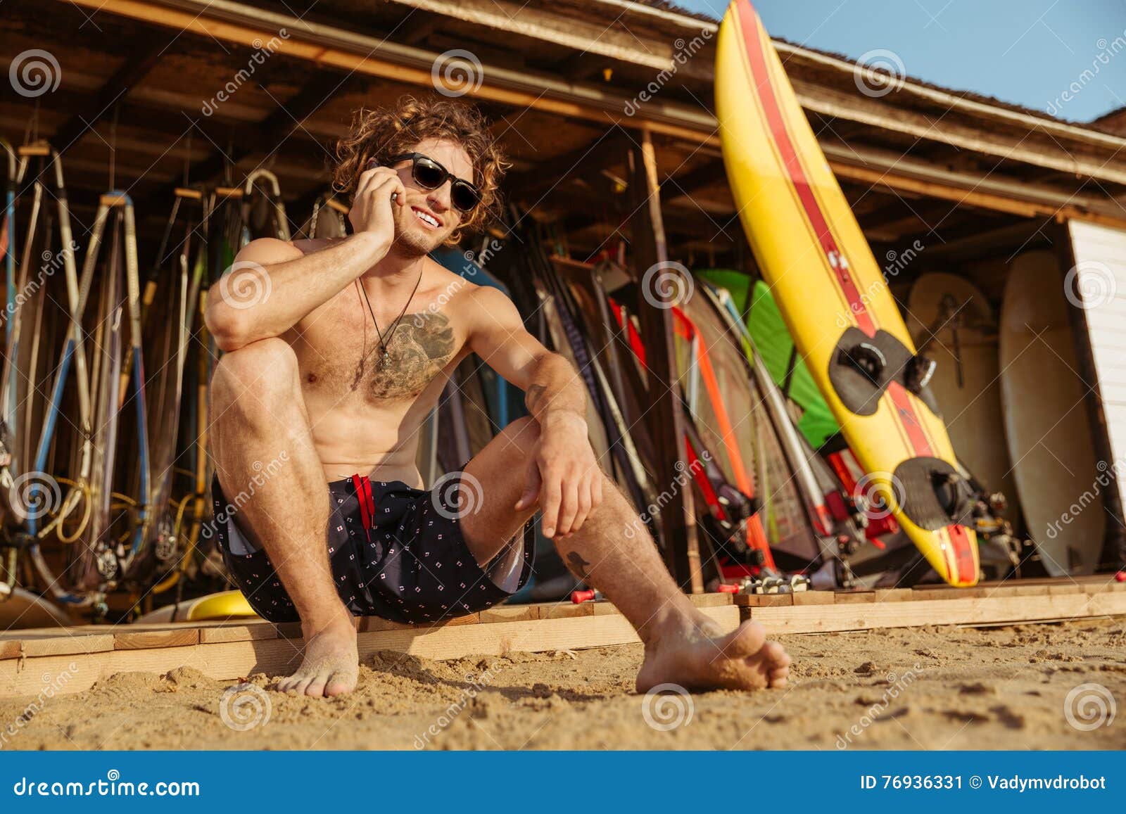 Surfer Man in Eyeglasses Sitting and Talking on Smartphone Outdoors ...