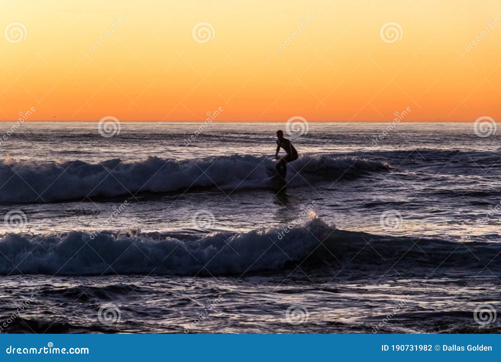 Surfer Riding Ocean Waves in the Sunset Stock Photo - Image of ...