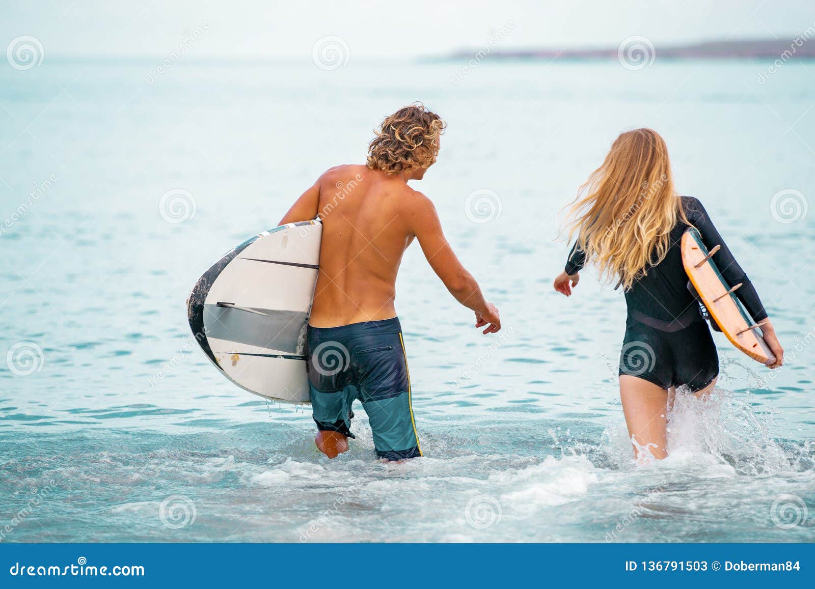 Surfers At The Beach Smiling Couple Of Surfers Walking On The Beach