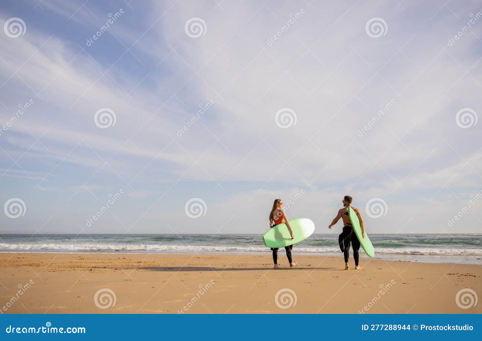 Surfing Together Young Couple With Surfboards Going Into The Ocean