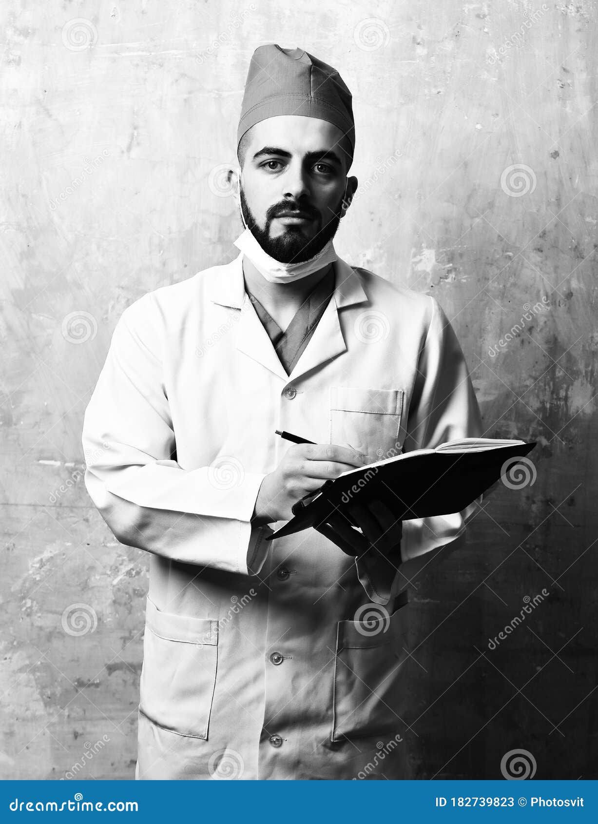 Surgeon with Beard and Tired Face Expression Writes in Notebook Stock ...