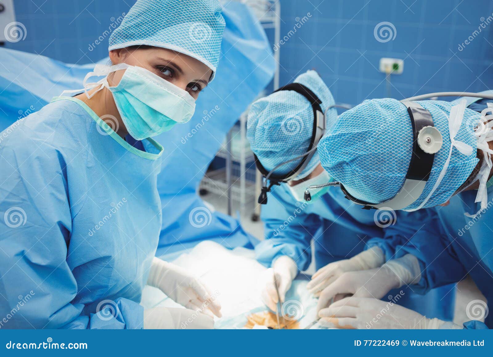 Surgeon Looking at Camera while Colleagues Performing Operation Stock ...